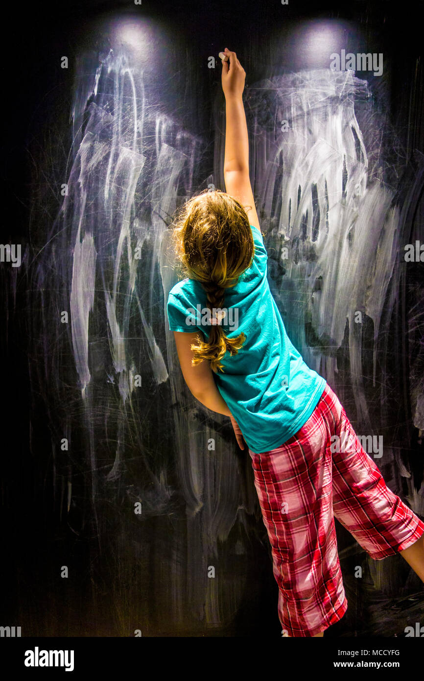 Young girl writing on chalkboard hi-res stock photography and images ...