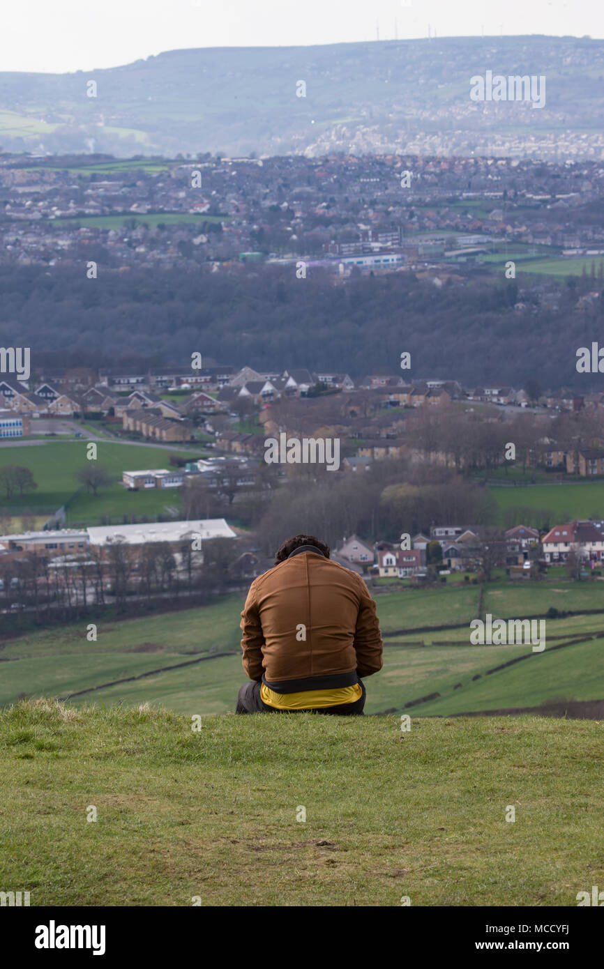 Solitary figure absorbed in texting with a panoramic view of West ...
