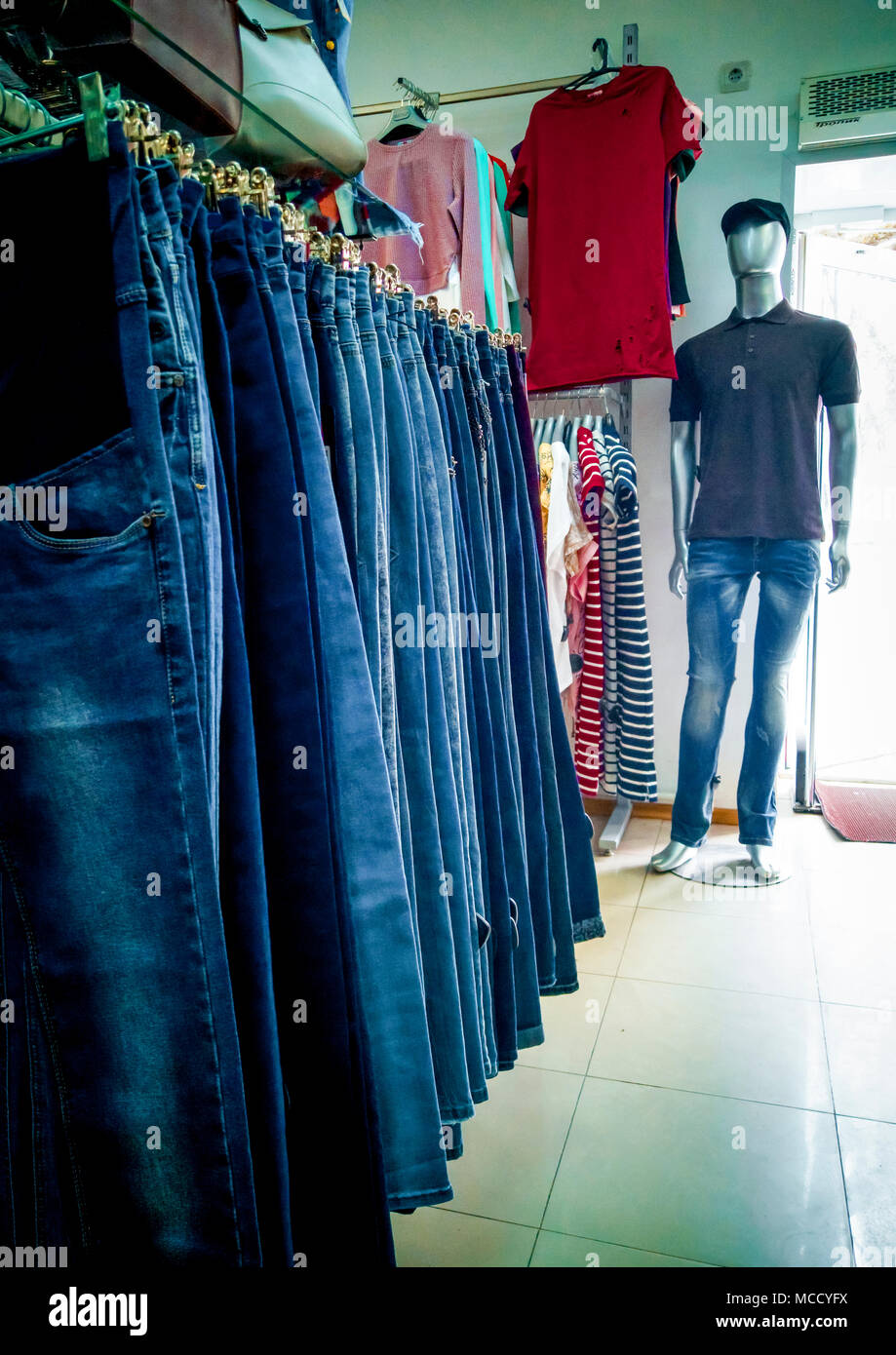 Goods hanging on hangers in the fashion store. At the entrance stands a ...