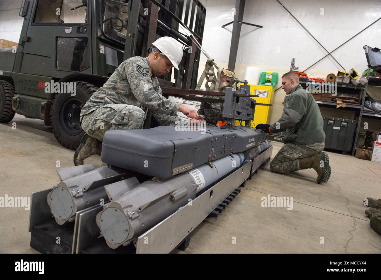 Airmen with the 3rd Munitions Squadron assemble a rack of inert small ...