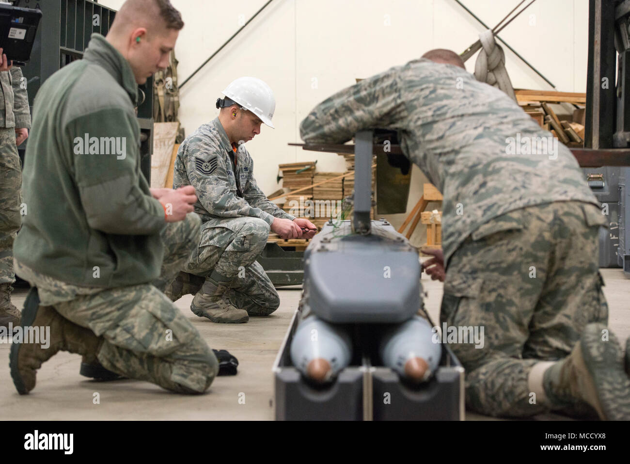 Airmen with the 3rd Munitions Squadron assemble a rack of inert small ...