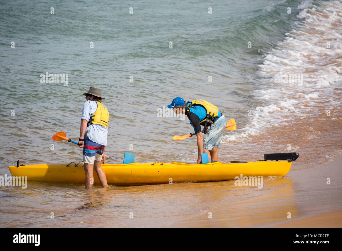 Two men with their ocean sea kayak boat on Avalon beach in Sydney ...