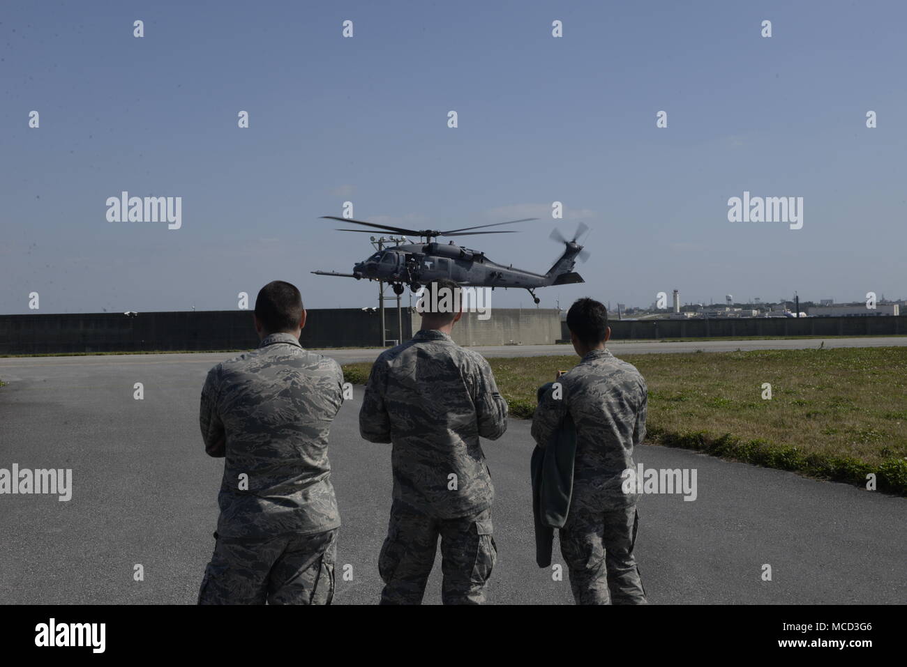 Airmen assigned to the 18th Wing Public Affairs office watch an HH-60G ...