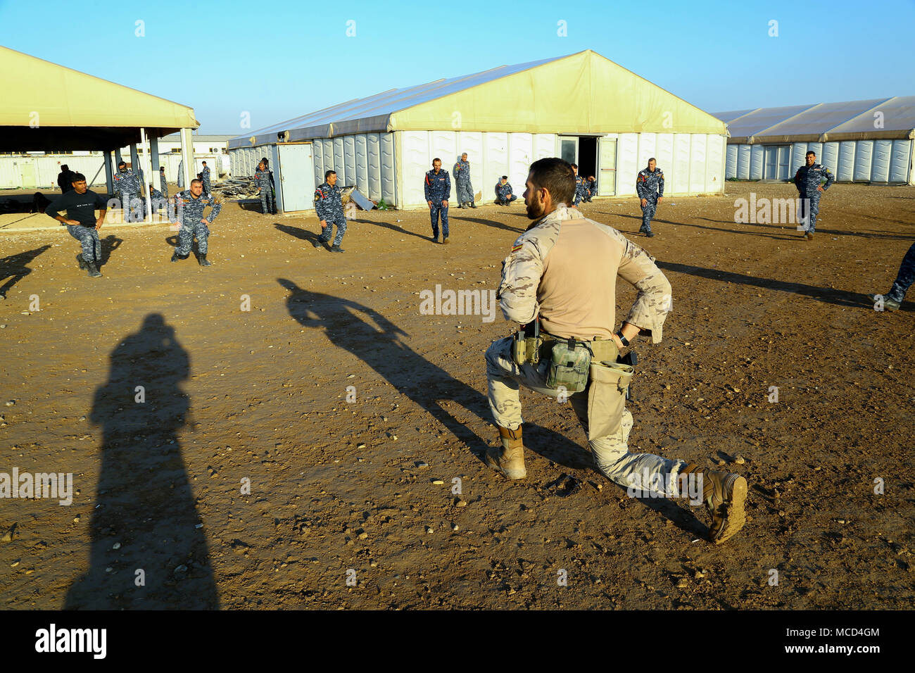 A Spanish trainer stretches with Iraqi soldiers attached to Commando ...
