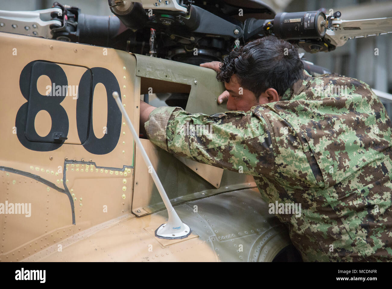 An Afghan Air Force MD-530 maintainer inspects the inside of a panel on ...