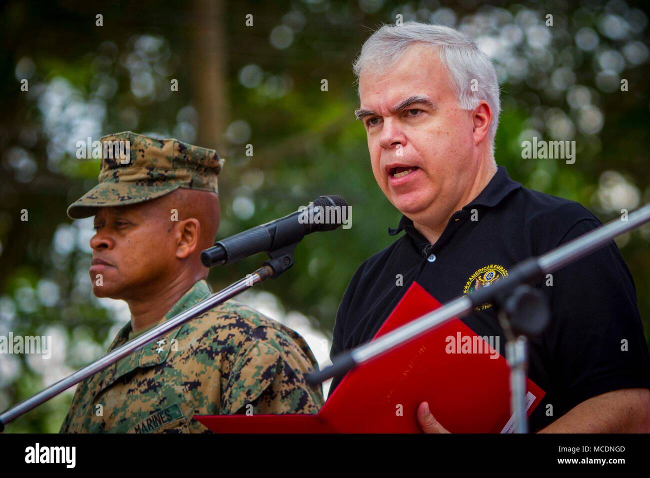 U.S. Deputy Chief of Mission Peter Haymond speaks next to U.S. Marine ...