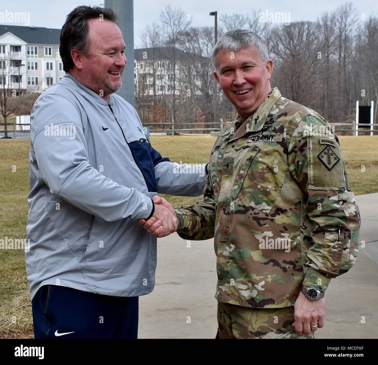 Rob Cooper, the head coach for the Penn State baseball team, shakes hands with Brig. Gen. James ...