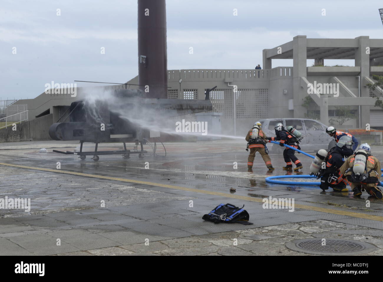 Local Japanese firefighters use their water hoses to put out a ...