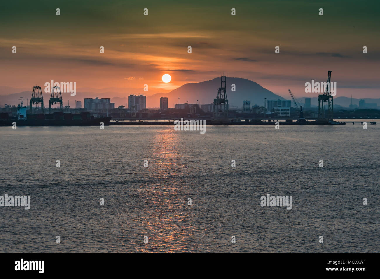 Sunrise from the sea in the port of Penang and in the background the ...