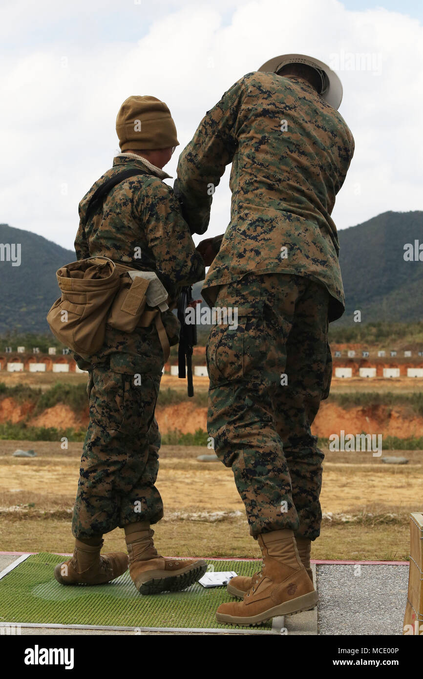 CAMP SCHWAB, OKINAWA, Japan – A range coach helps a Marine adjust her ...