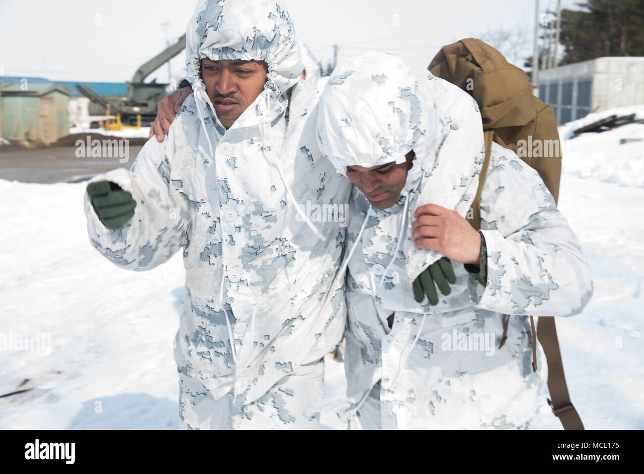 U.S. Marine Corps Lance Cpl. Brian Rubenacker helps a simulated ...