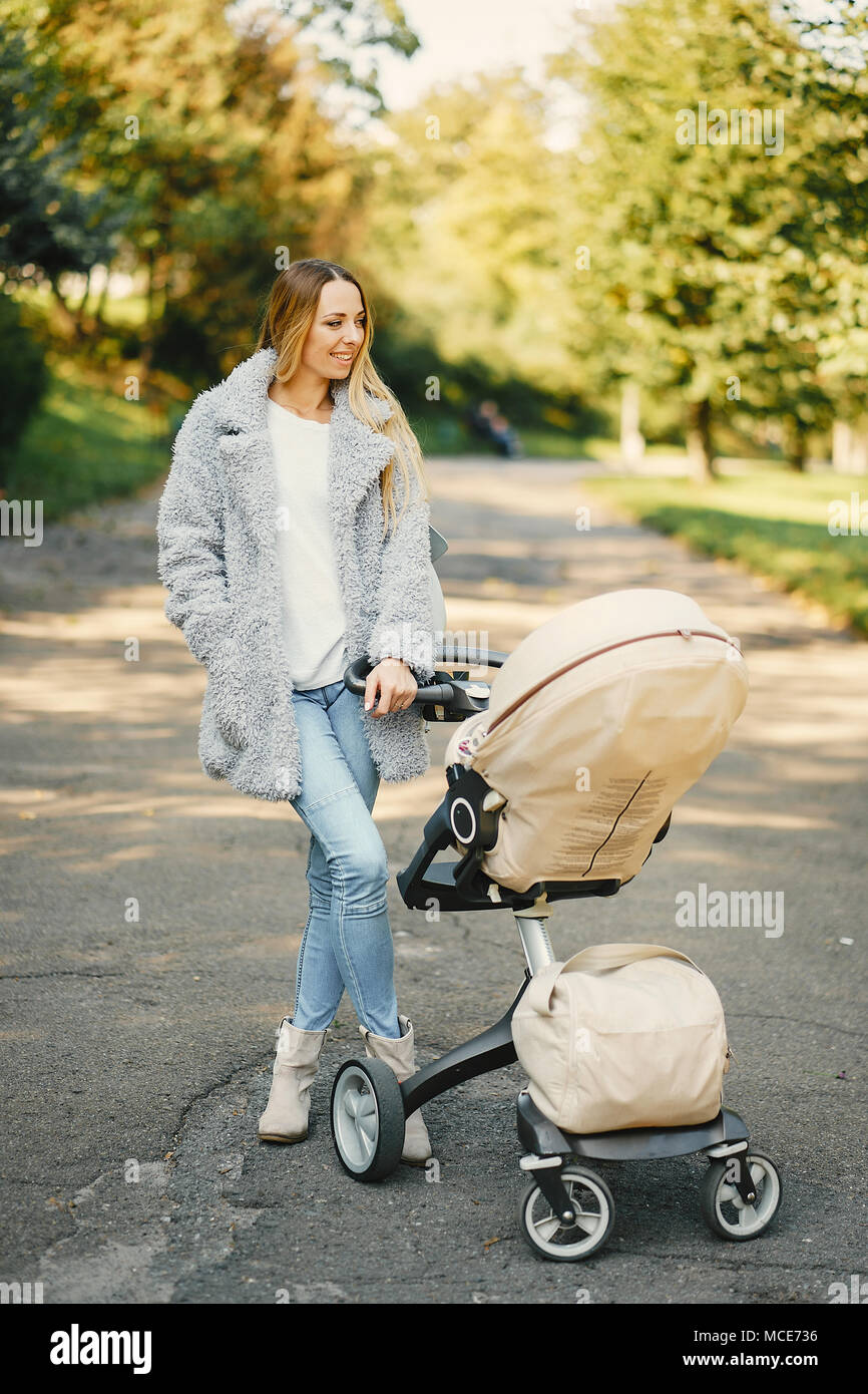 young mother pushing a stroller Stock Photo - Alamy