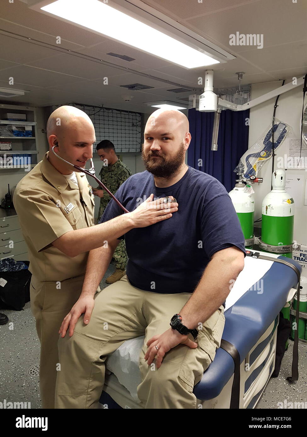 LCDR Eric Vaught checks the heartbeat of a Sailor assigned to the USNS ...