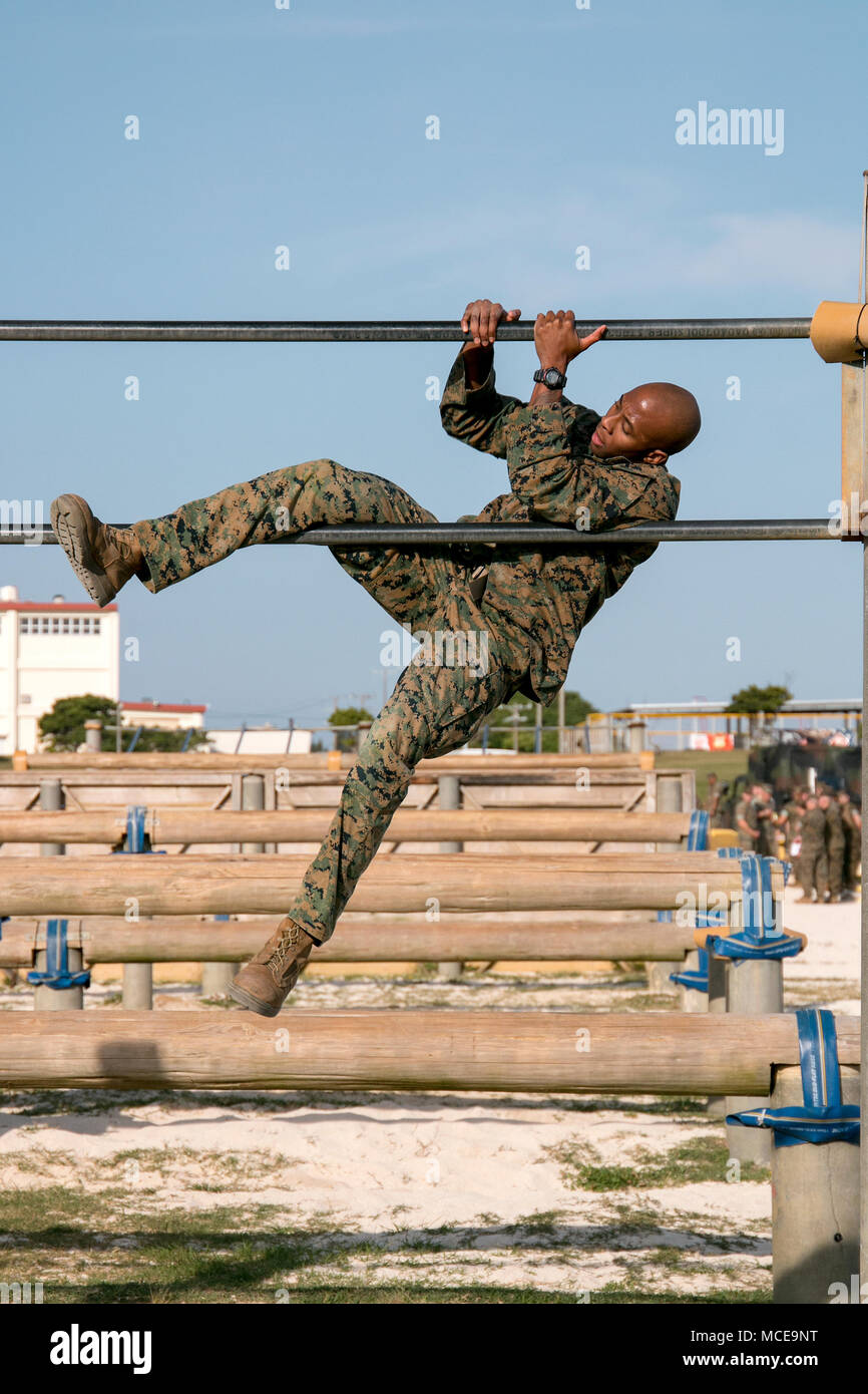 HM2 Norman Rhodes climbs a set of bars while running the obstacle ...