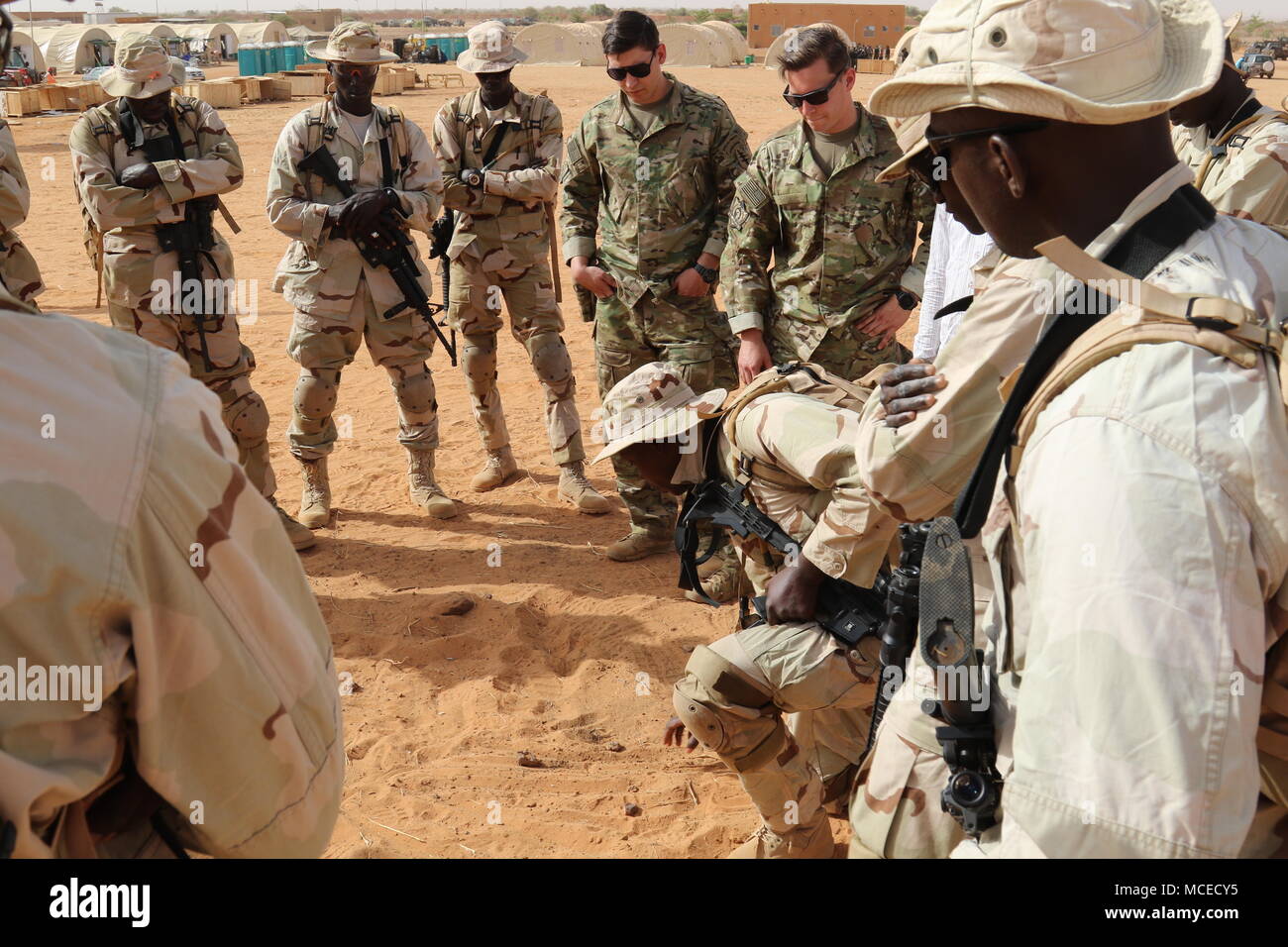 A Senegalese squad leader uses rocks to explain movement techniques ...