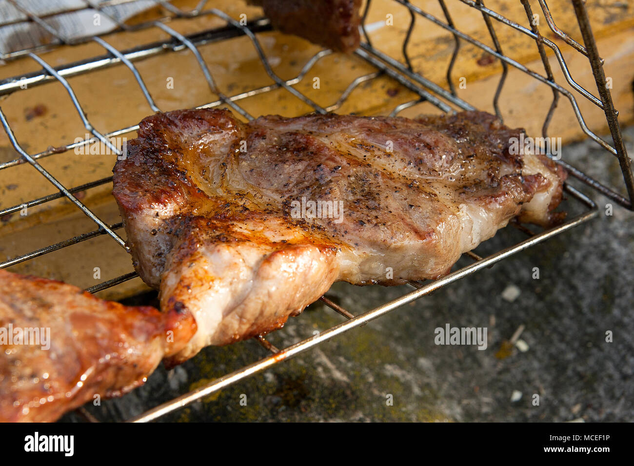 Close up view of juicy slices of meat cooked on an open flame grill ...