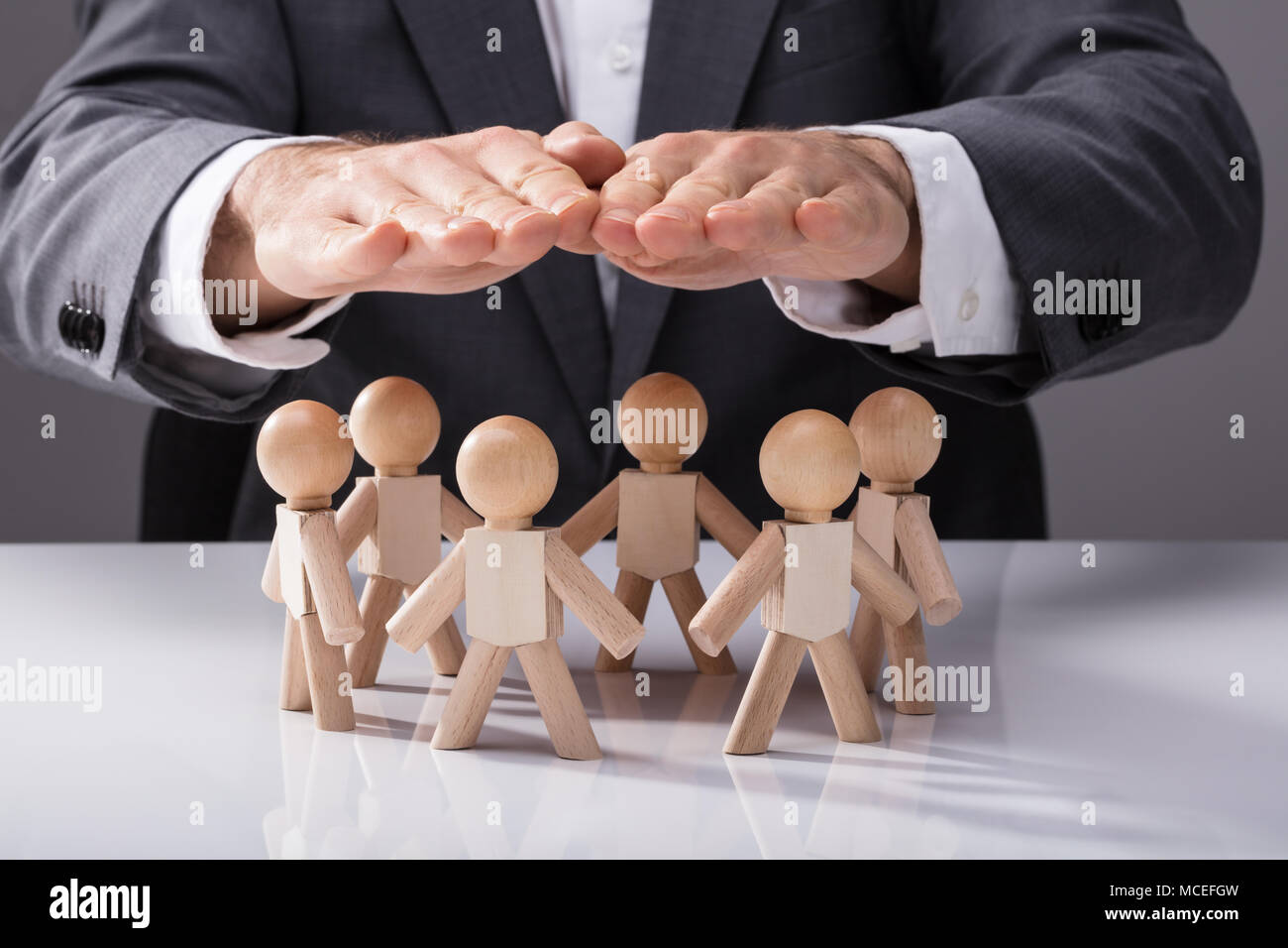 Human Hand Protecting Wooden Figures On White Background Stock Photo ...