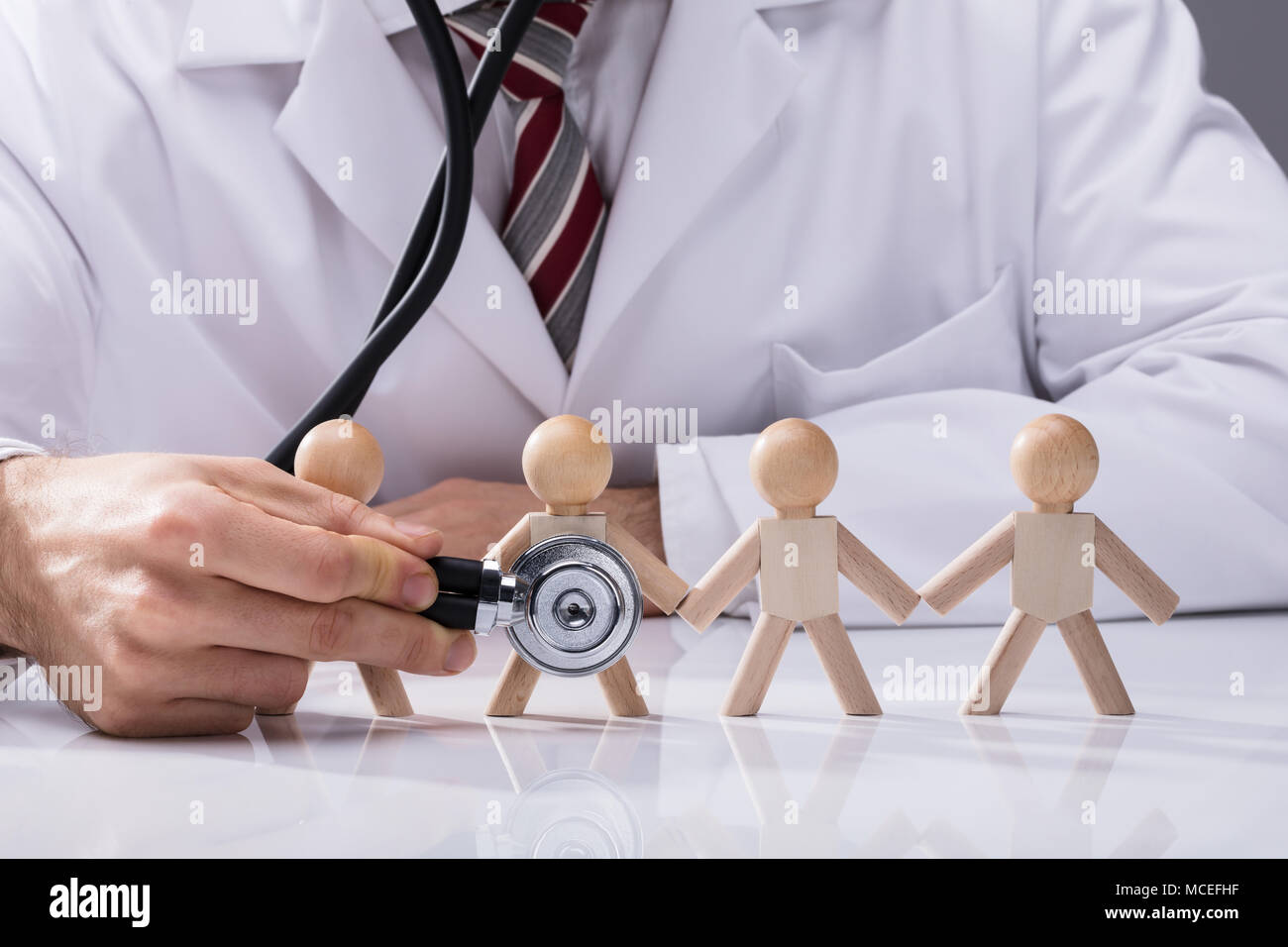 Close-up Of A Doctor's Hand Examining Wooden Human Figures With ...