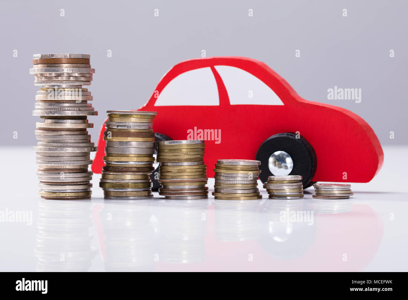 Red Car Over Stacked Coins Against Grey Background Stock Photo - Alamy Red Car Over Stacked Coins Against Grey Background Stock Photo - Alamy