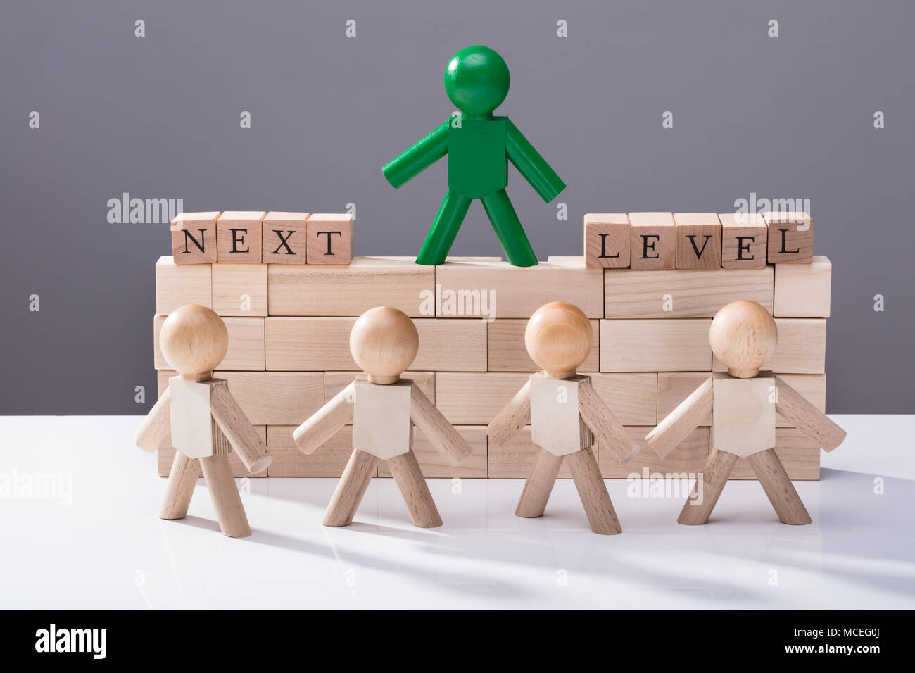 Row Of Figures In Front Of Figure Standing On Top Of Wooden Blocks ...
