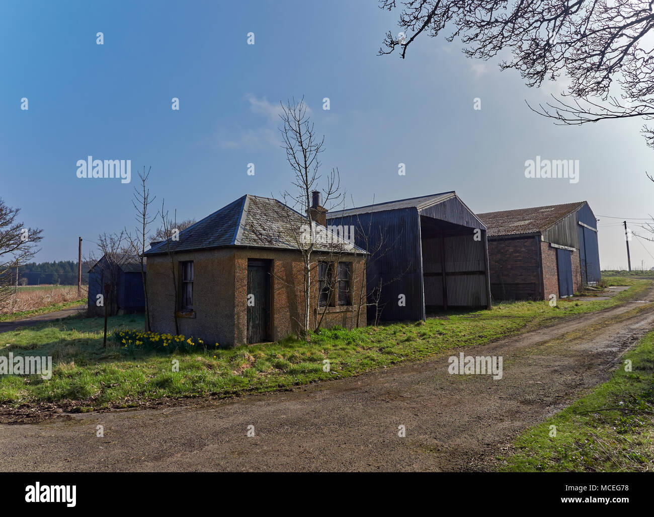 A Tiny Farm Cottage lies besides 2 Farm Barns along a Farm Track in the ...