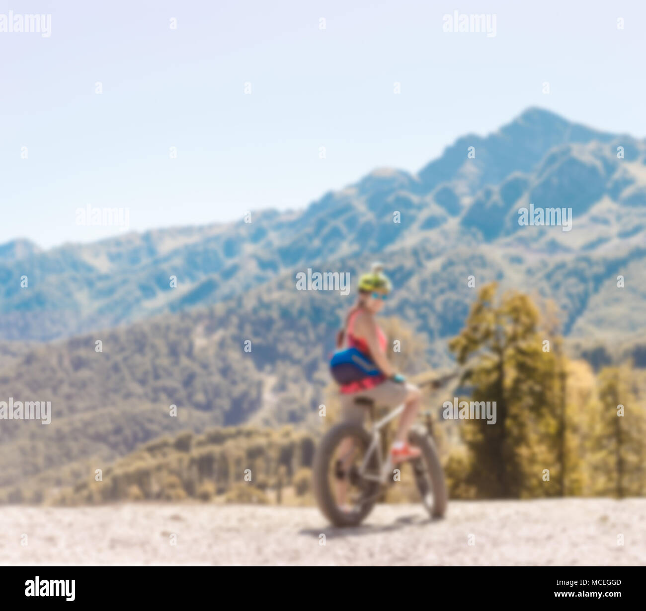 Blurred photo of woman in helmet riding bike Stock Photo - Alamy