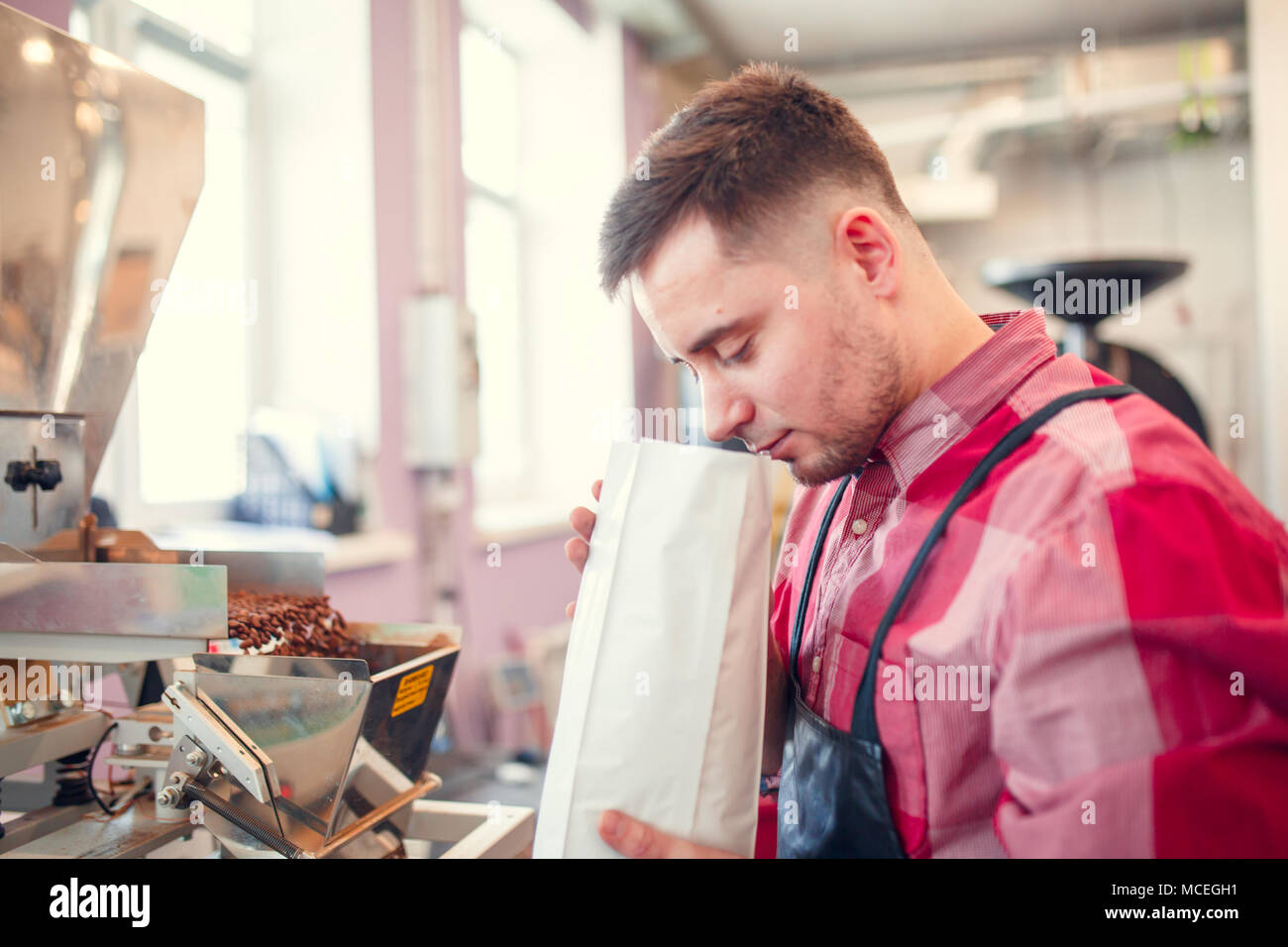 Photo of man sniffing coffee in paper bag Stock Photo - Alamy