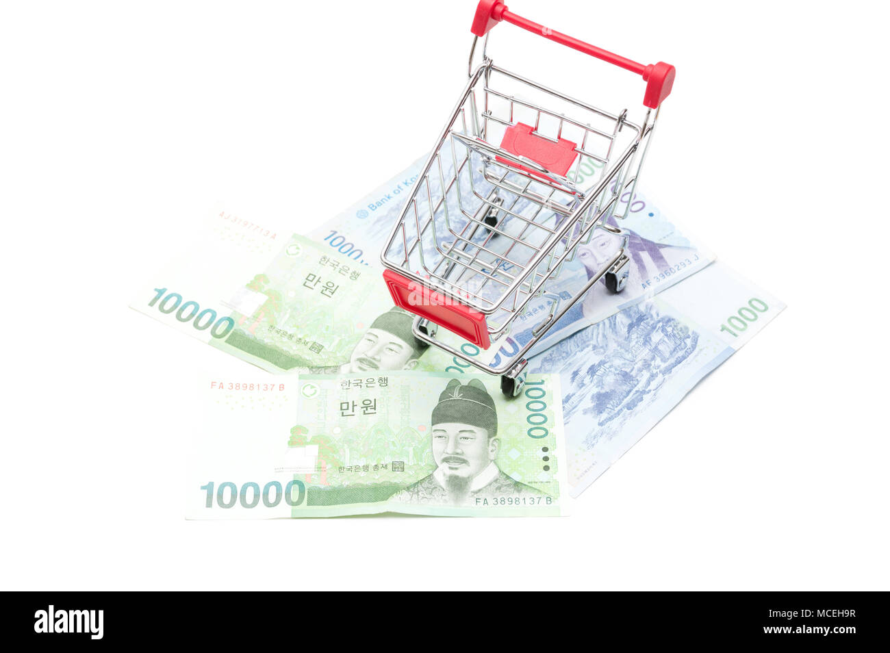 Korean money and shopping cart on white background : economy concept ...