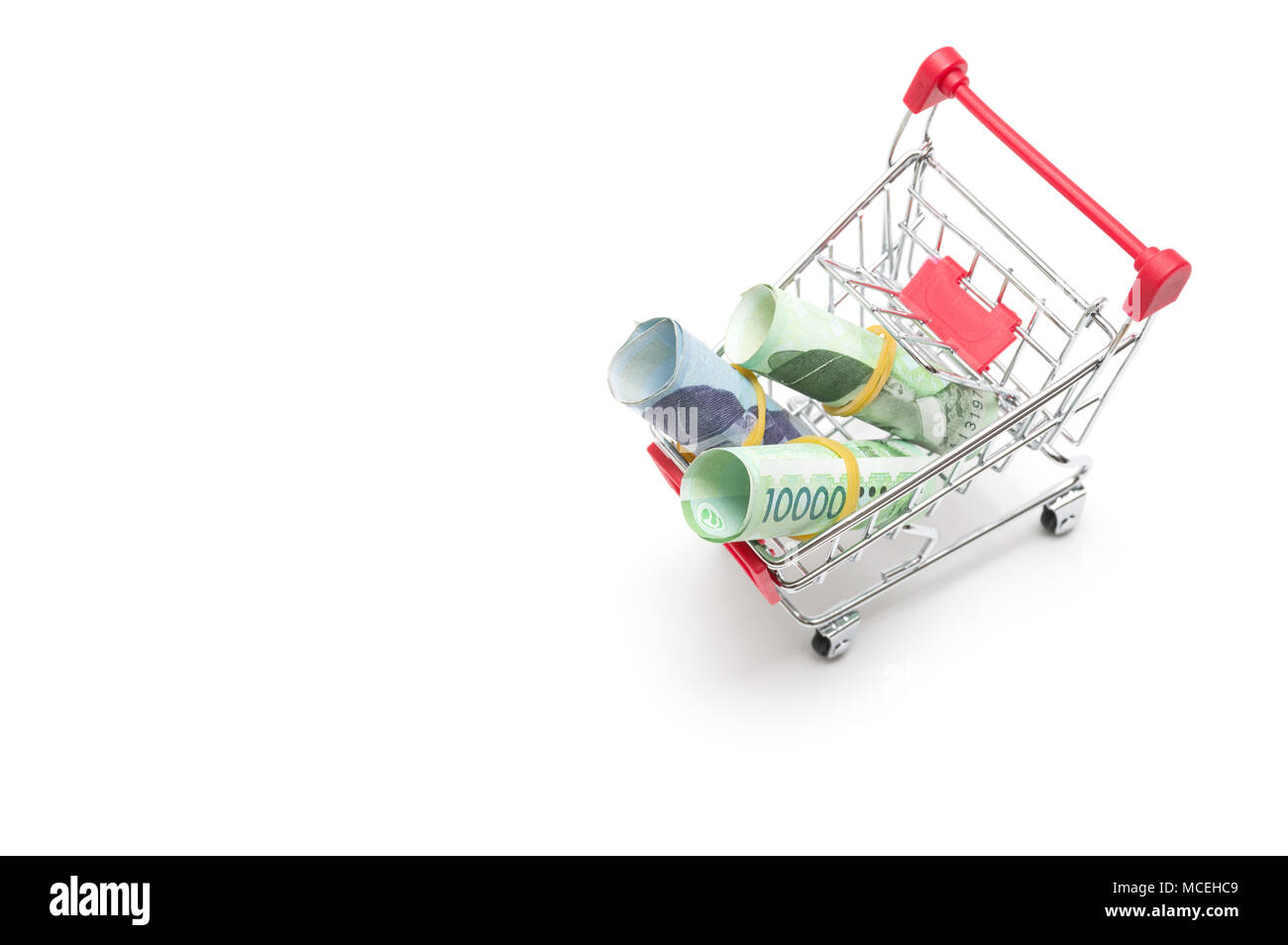 Korean money and shopping cart on white background : economy concept ...