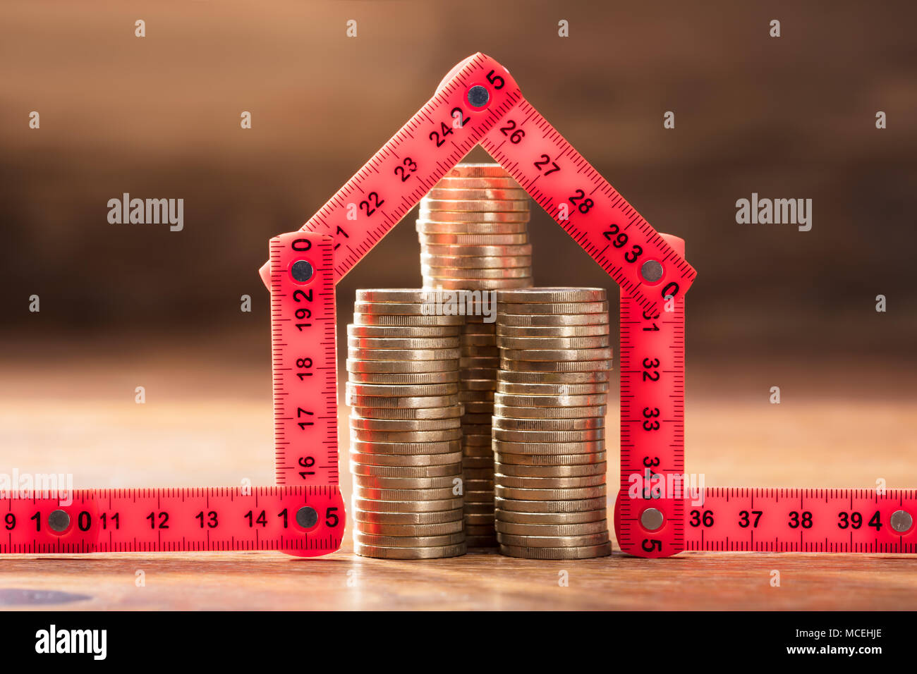 Stack Of Coins Under The House Made With Red Measuring Tape On The ...