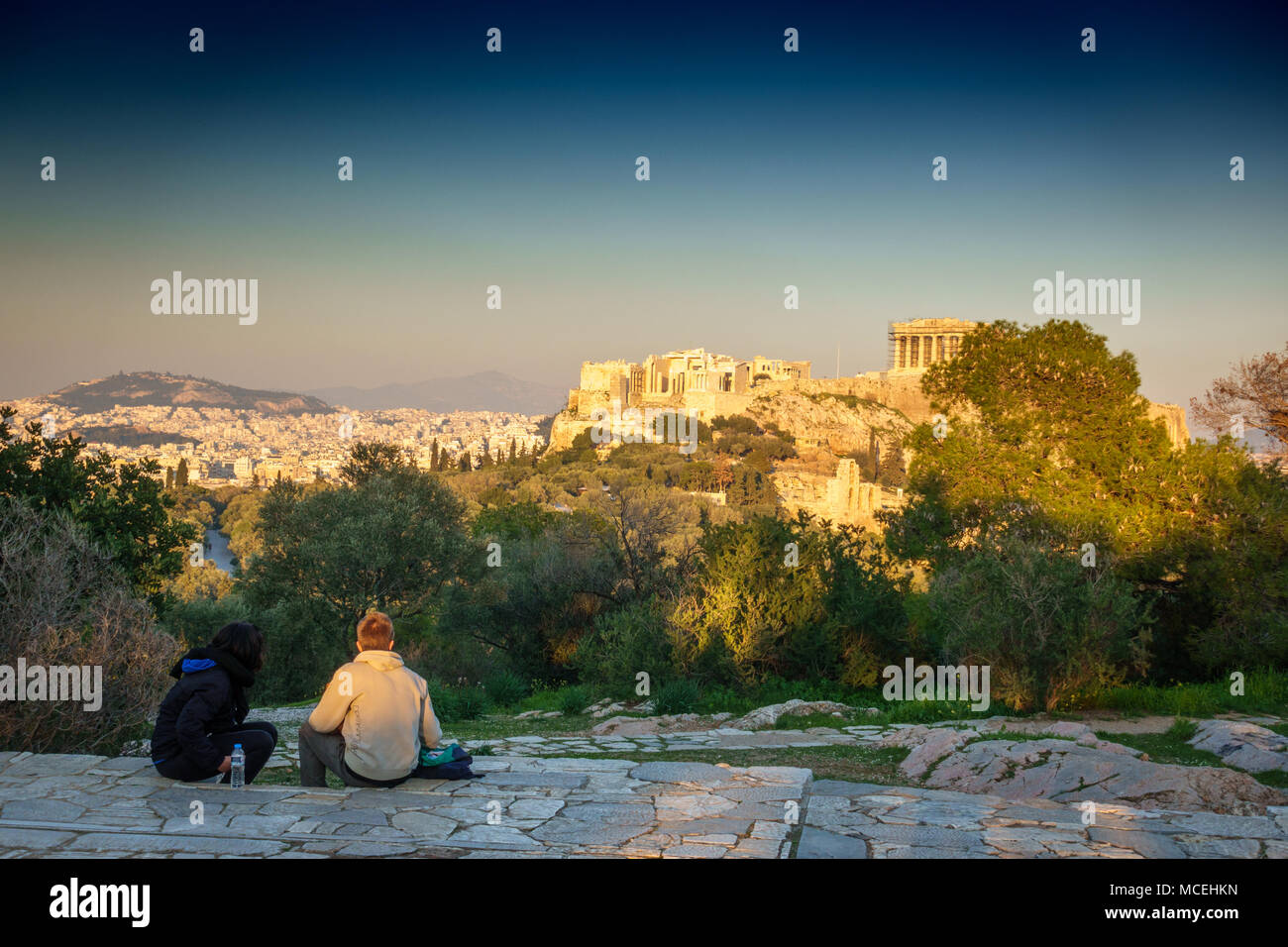 Rear view of a couple sightseeing The Acropolis - Athens, Greece from a ...