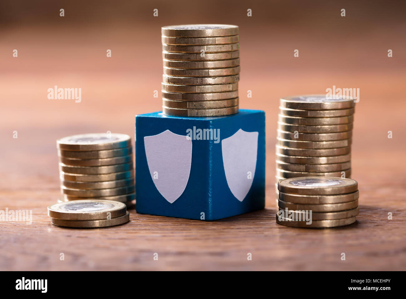 Stack Of Coins With Security Blocks On Wooden Block Stock Photo - Alamy