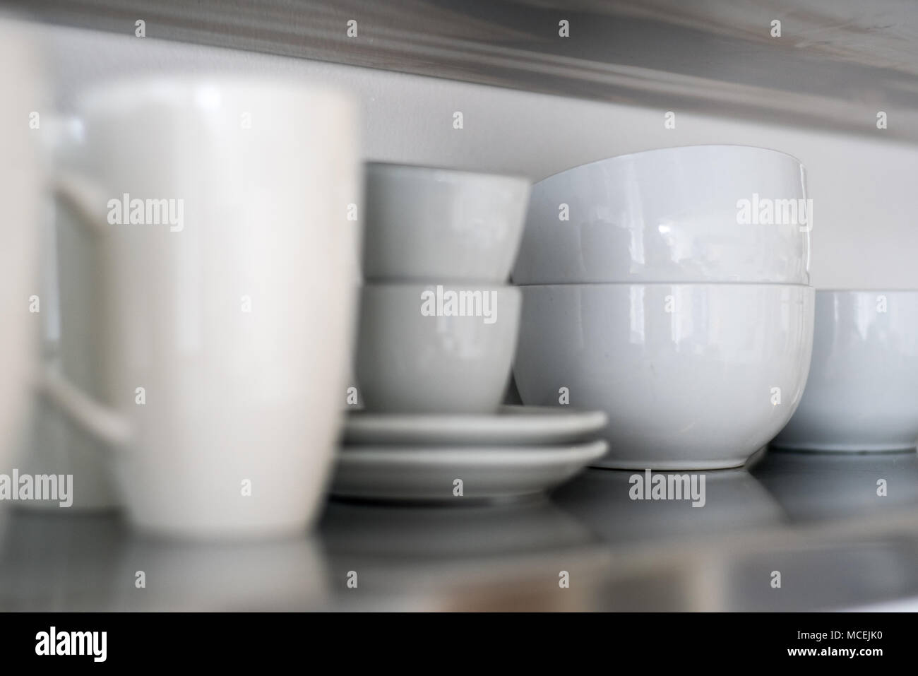 Ceramic bowls and mugs on kitchen shelf Stock Photo - Alamy