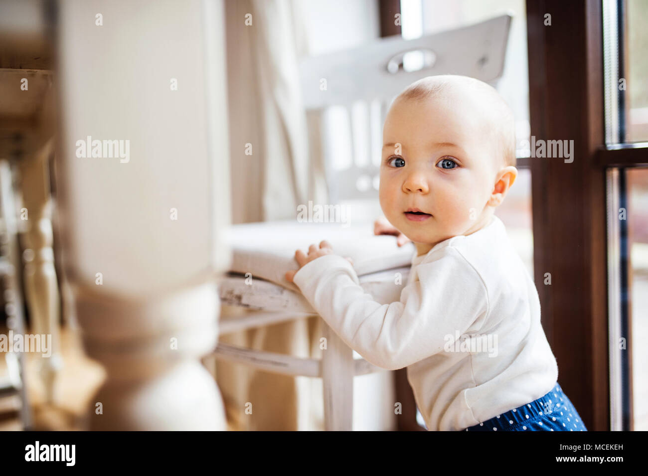 A toddler girl standing at the table at home Stock Photo - Alamy