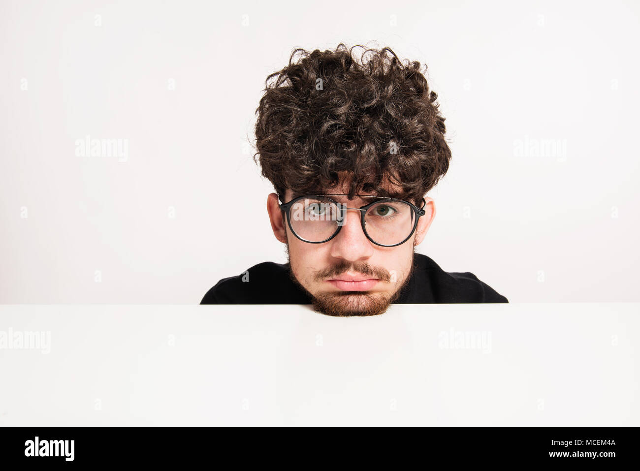 Young man in a studio, a head on the table Stock Photo - Alamy