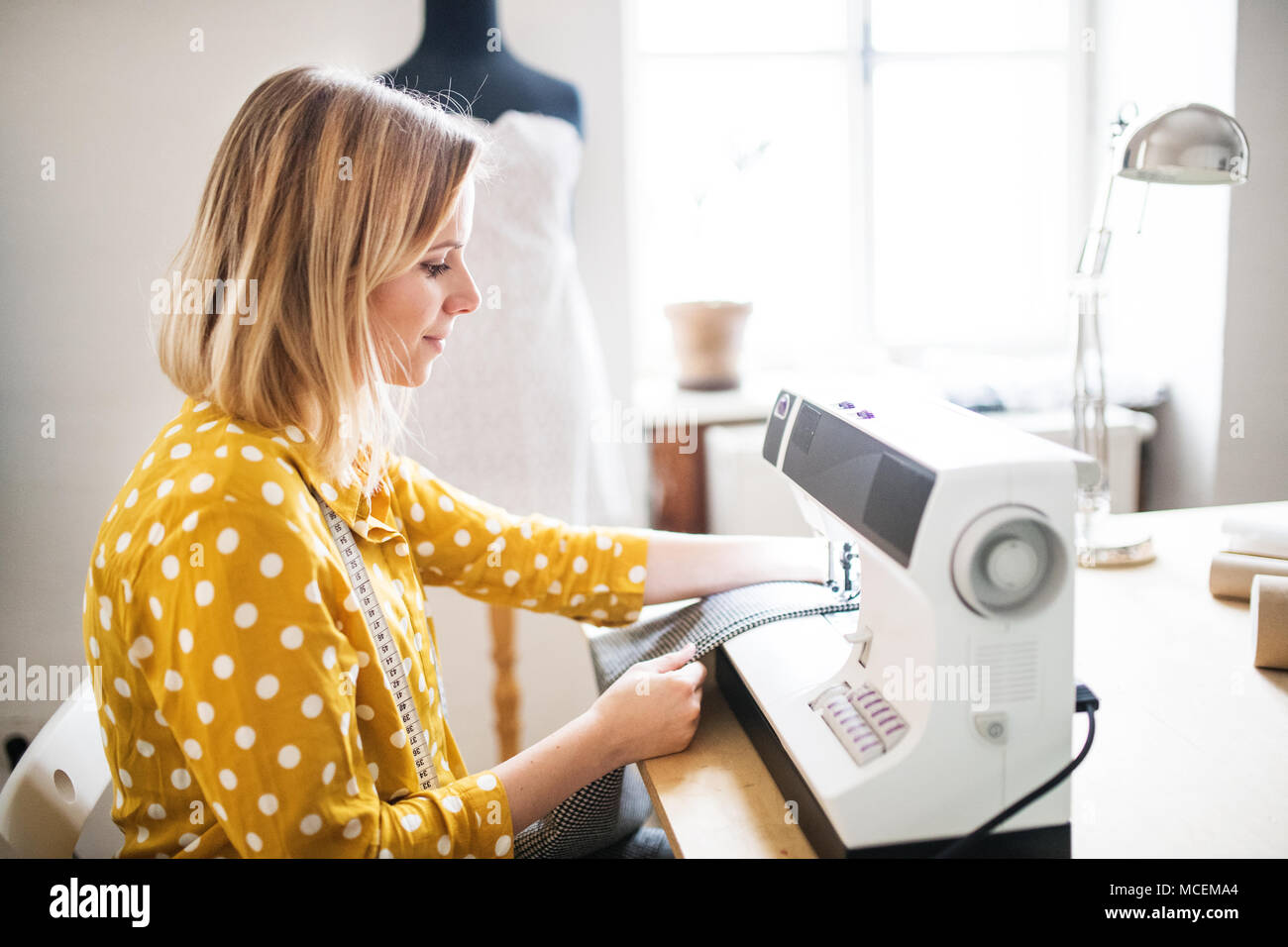 Young woman using sewing machine, startup business Stock Photo - Alamy