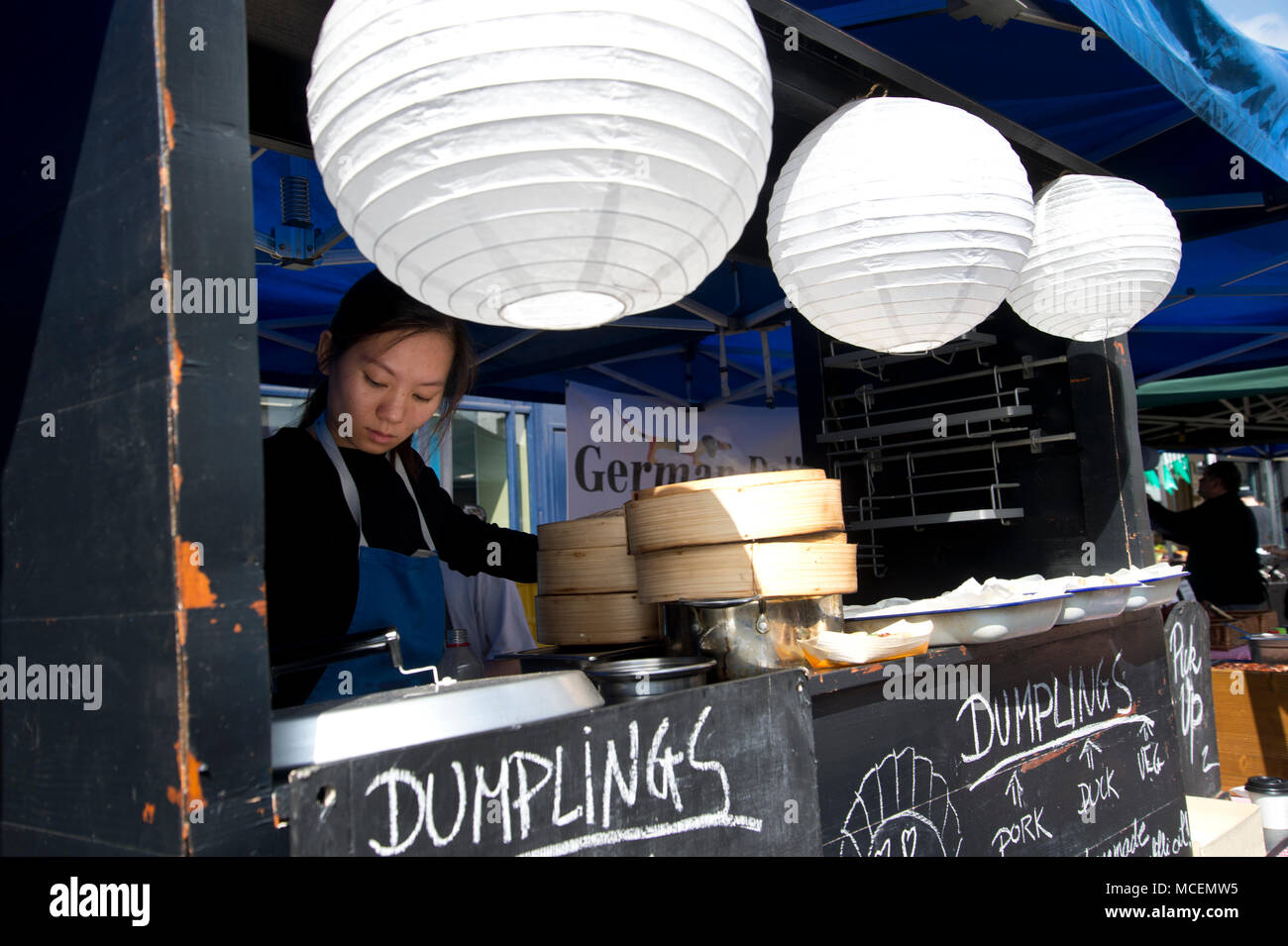 Hackney,London. Broadway Market. A woman prepares food on a dumpling ...