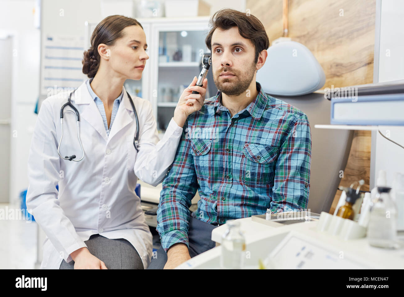 Doctor examining ear of her patient at hospital Stock Photo - Alamy