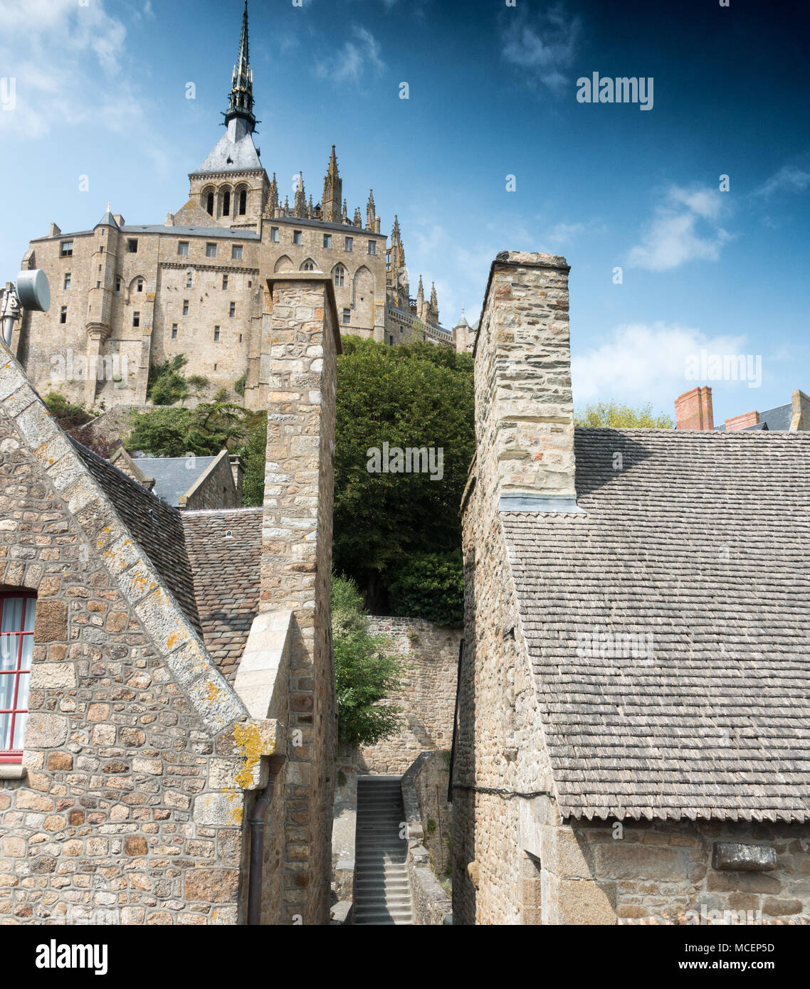 Low angle view of the castle from in between stonewalled houses ...