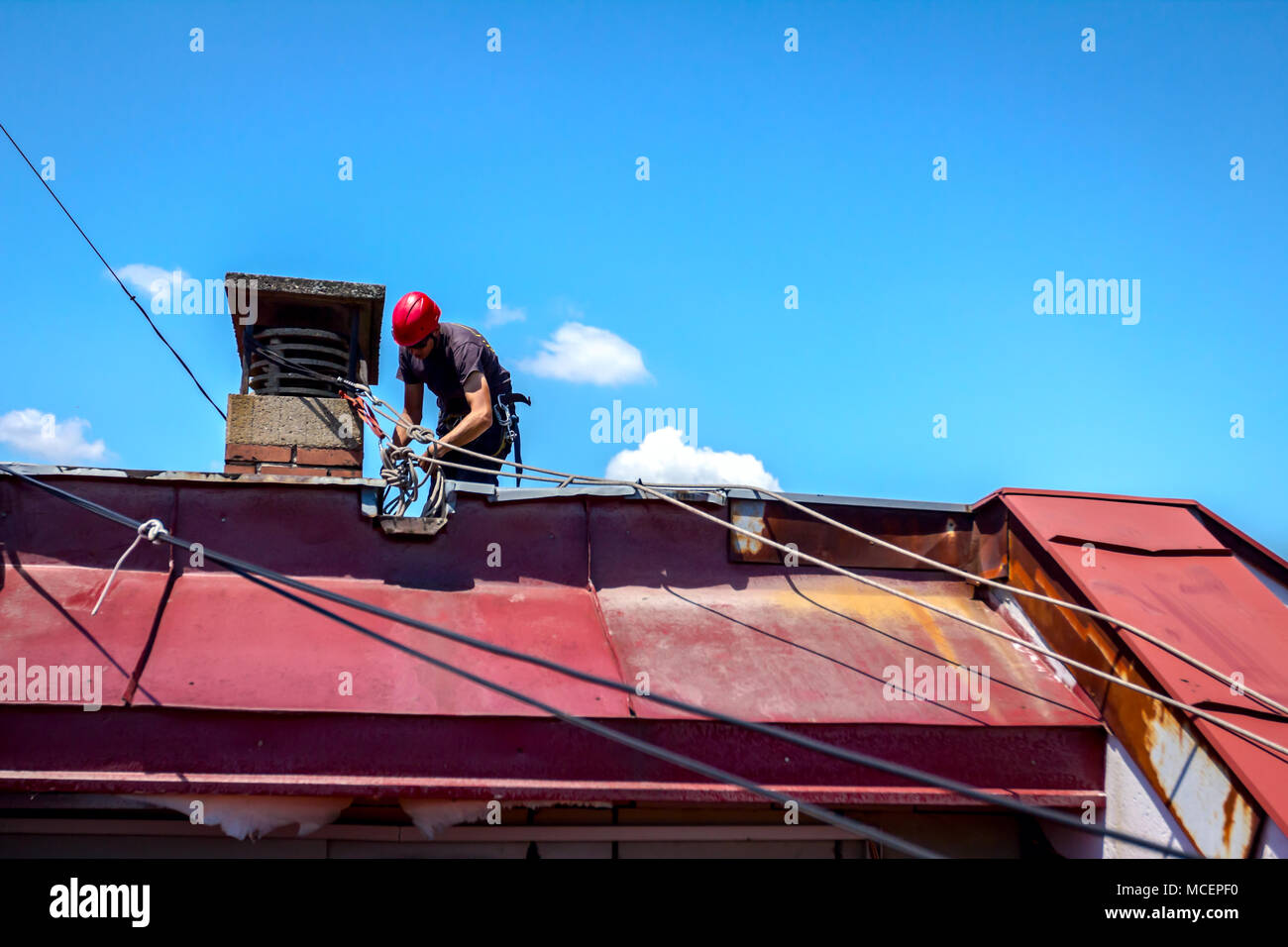 Industrial climber, alpinist, is adjusting climbing gear, preparing ...