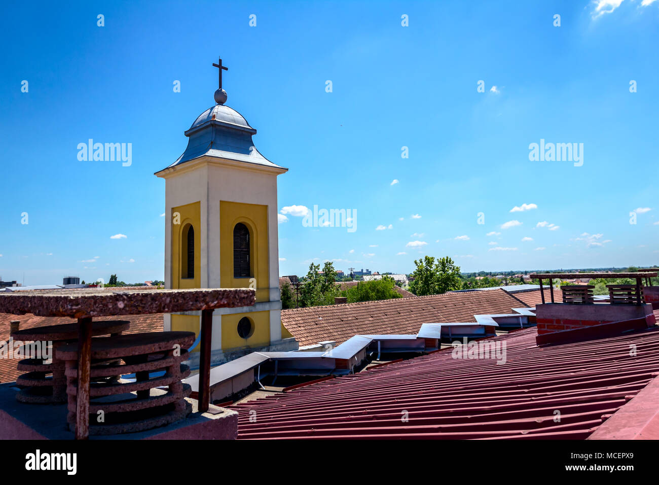 View on the church steeple with metal roof, long city street is below ...