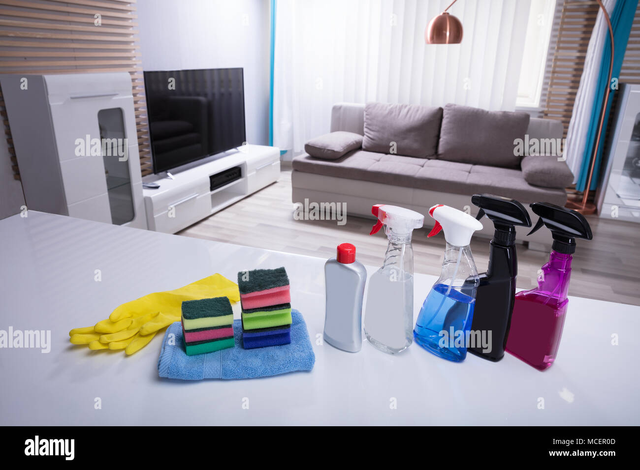 Different Cleaning Spray Bottles With Sponge And Gloves On White Desk ...