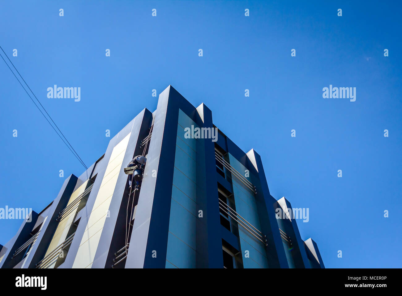 View from below on young man, industrial climber at work, he washing ...