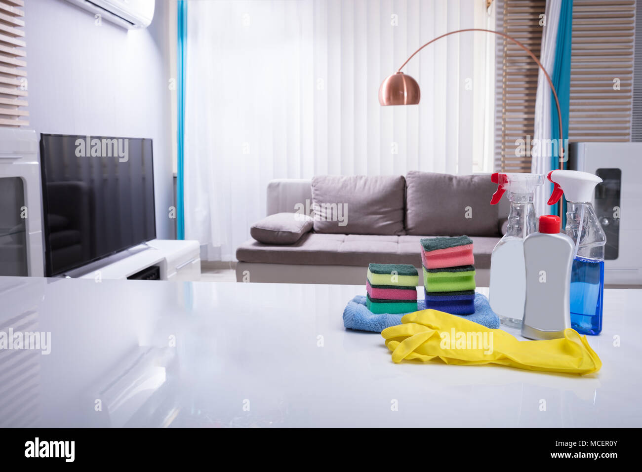 Different Cleaning Spray Bottles With Sponge And Gloves On White Desk ...