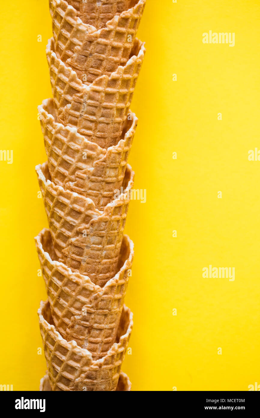 Empty waffle wafer ice cream cone on a bright yellow background Stock ...