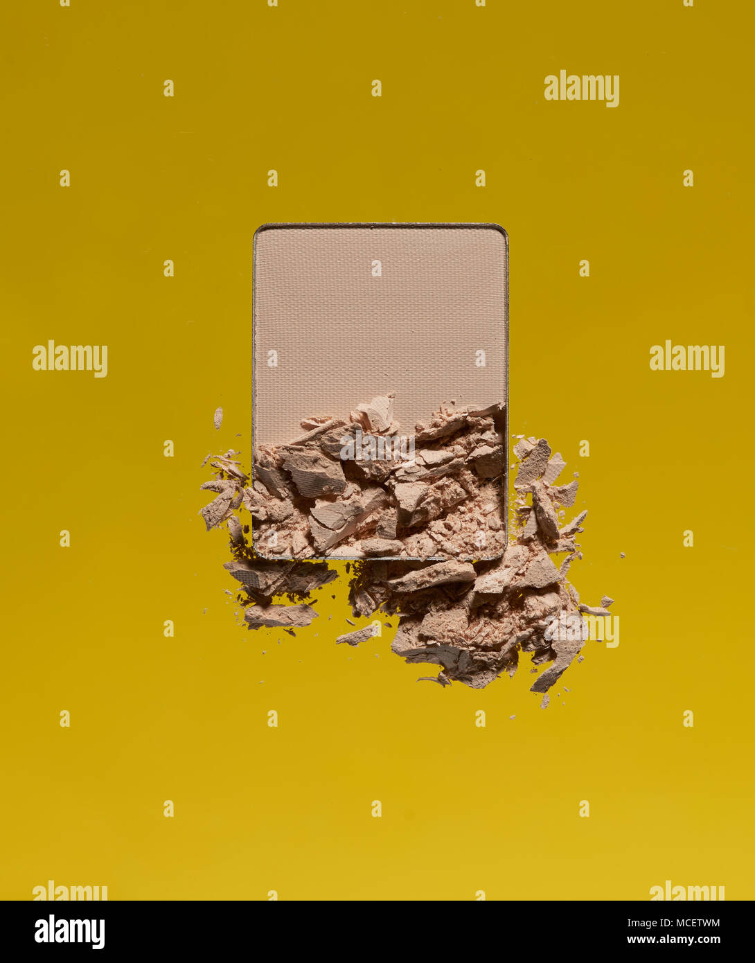 Make up crushed light beige shadow on mustard yellow color background ...