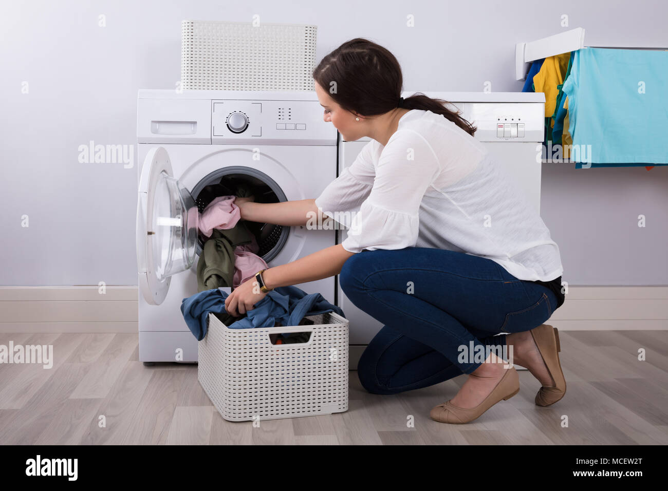 Side View Of A Young Woman Loading Clothes In Washing Machine Stock ...