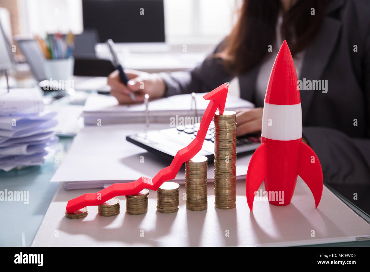 Close-up Of Red Rocket Besides Stacked Coins And Arrow Showing Upward ...