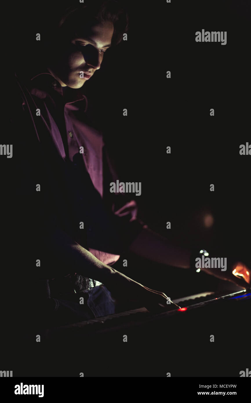 Guy playing on synthesizer keyboard Stock Photo - Alamy