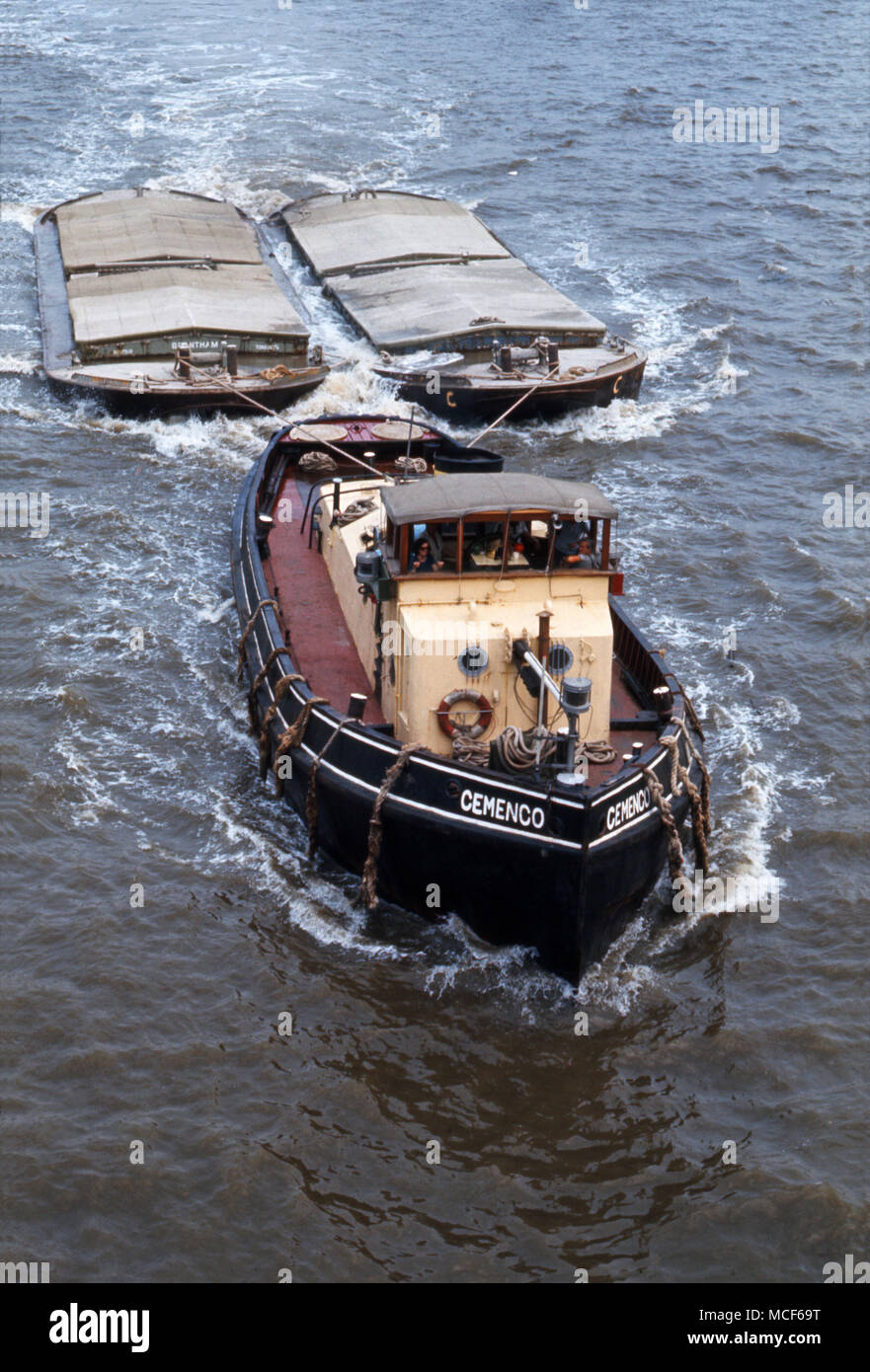 Tug pulling two barges on river Thames, London, England, 1976 Stock ...